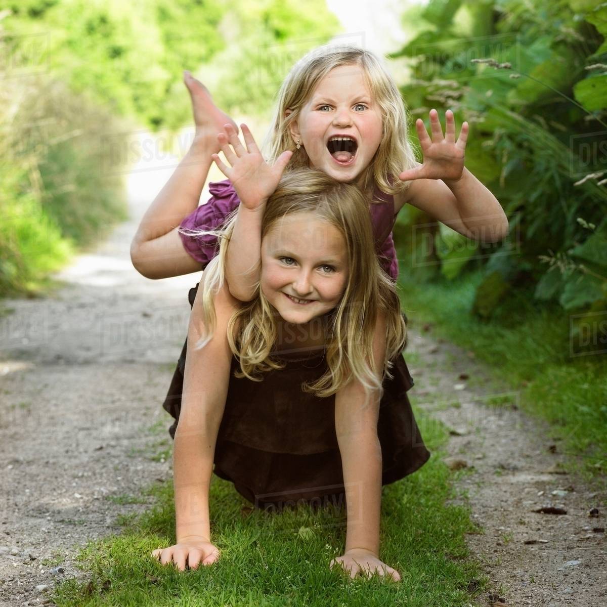Girls playing together on dirt path - Stock Photo - Dissolve