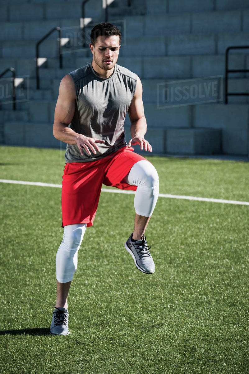 Young man training, running in place on playing field - Stock Photo ...