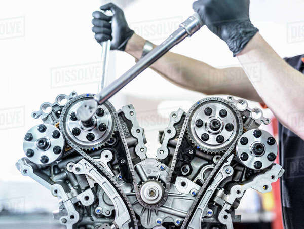 Engineer working on engine in racing car factory, close up - Stock ...