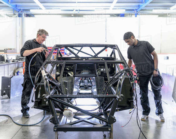 Engineers working on racing car in racing car factory - Stock Photo ...