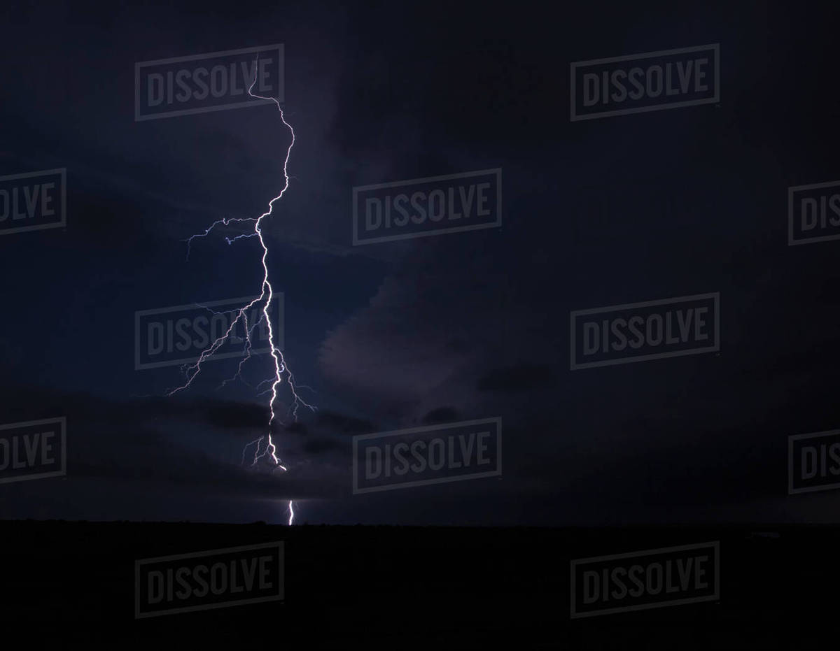 A forking lightning bolt arcs from the anvil of a tornadic thunderstorm ...