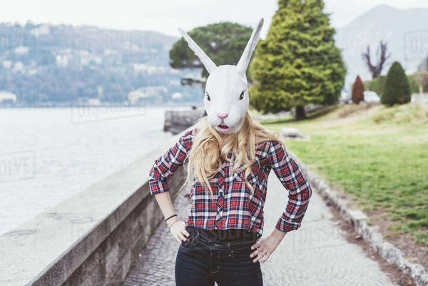 Portrait of woman wearing rabbit mask with hands on hips, Lake Como ...