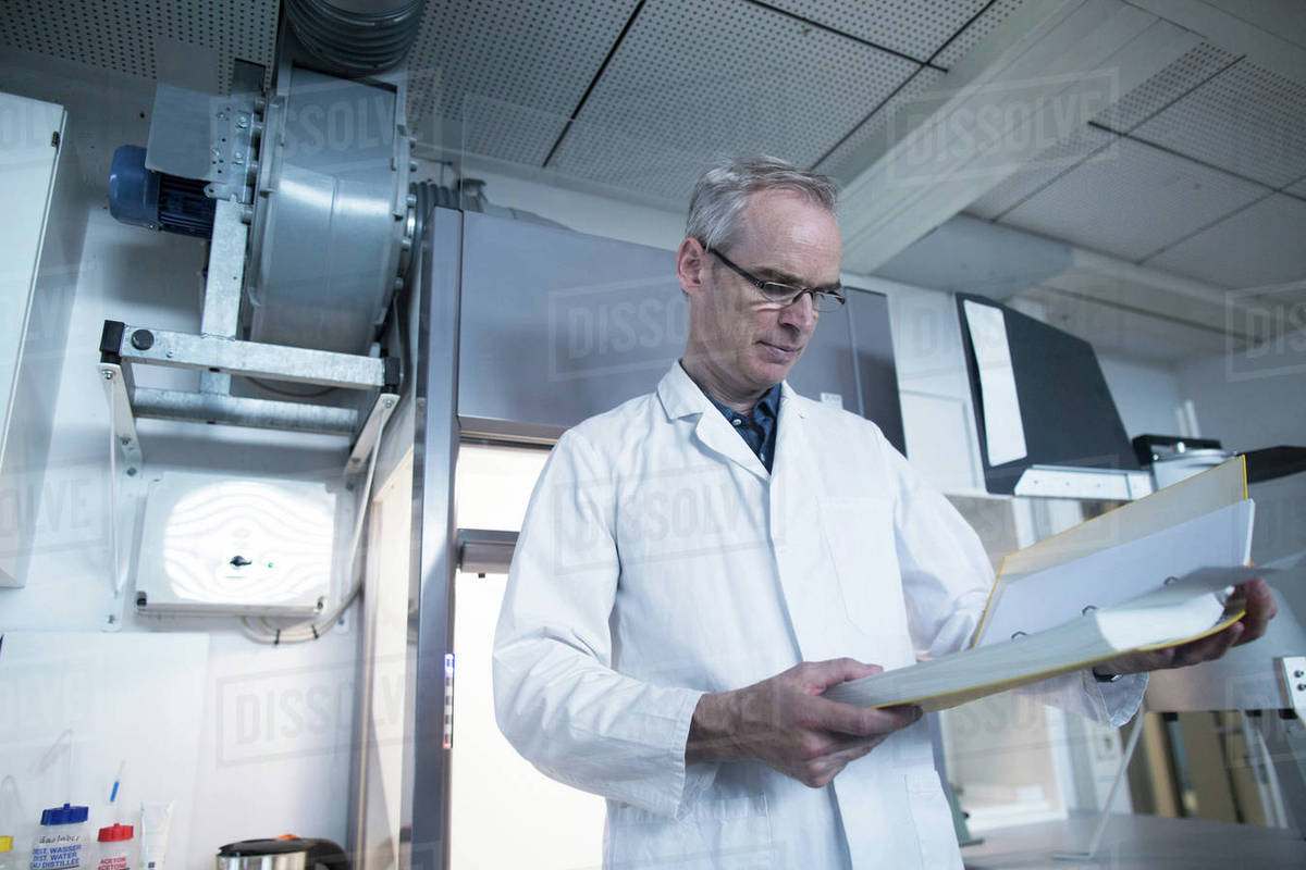 Male meteorologist reviewing data file from weather station laboratory ...