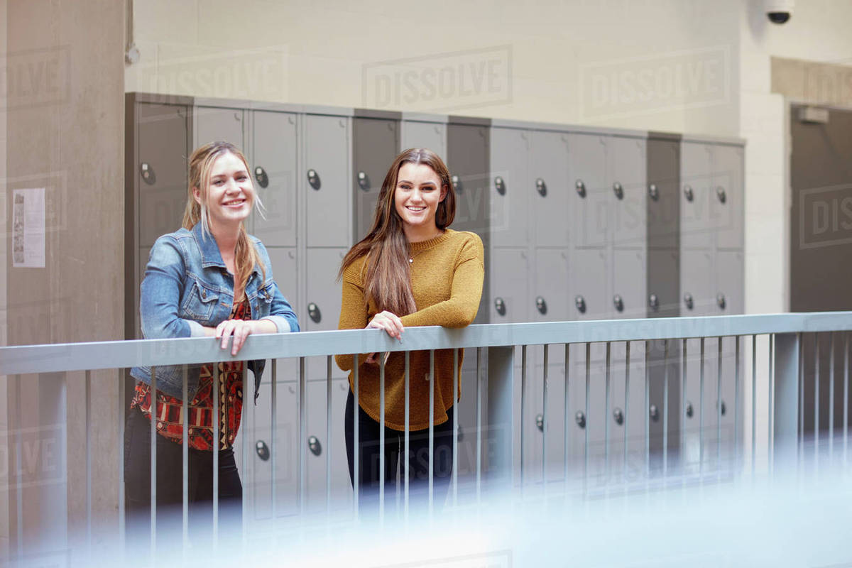 Portrait of two female students in higher education college locker room ...