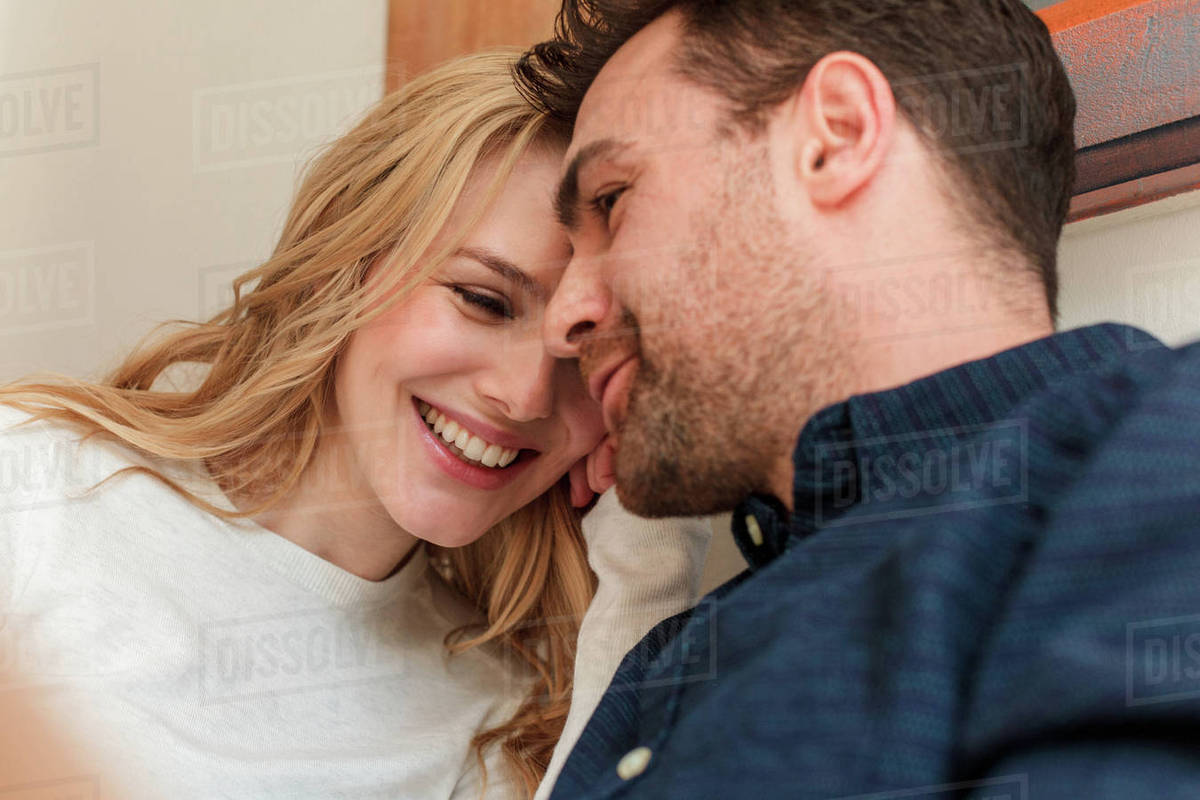 Couple snuggling together smiling - Royalty-free Stock Photo | Dissolve