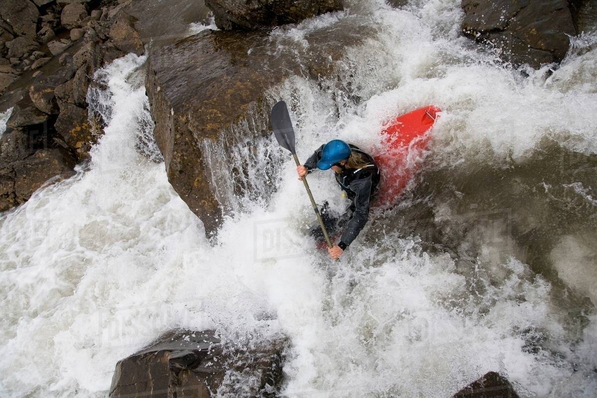 Man canoeing over rocky waterfall - Royalty-free Stock Photo | Dissolve