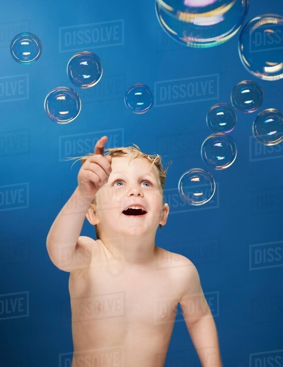Boy popping bubbles in bath - Royalty-free Stock Photo | Dissolve