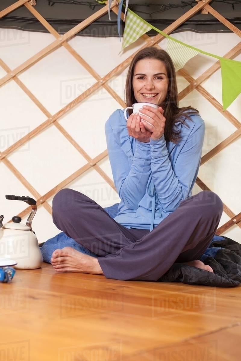 Woman drinking tea in living room - Royalty-free Stock Photo | Dissolve