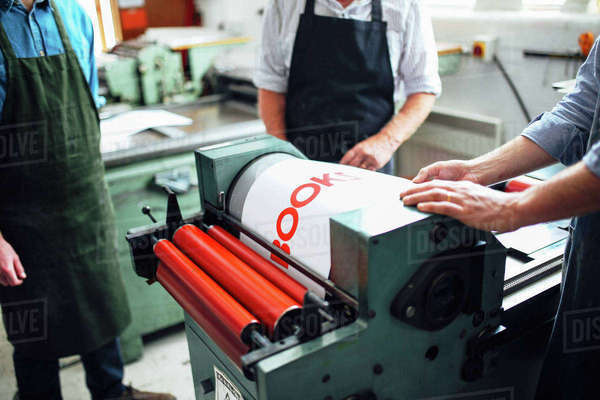 Craftspeople being shown how to use letterpress machine in book arts ...