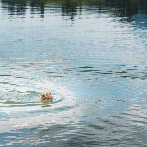 Boy swimming in lake - Stock Photo - Dissolve