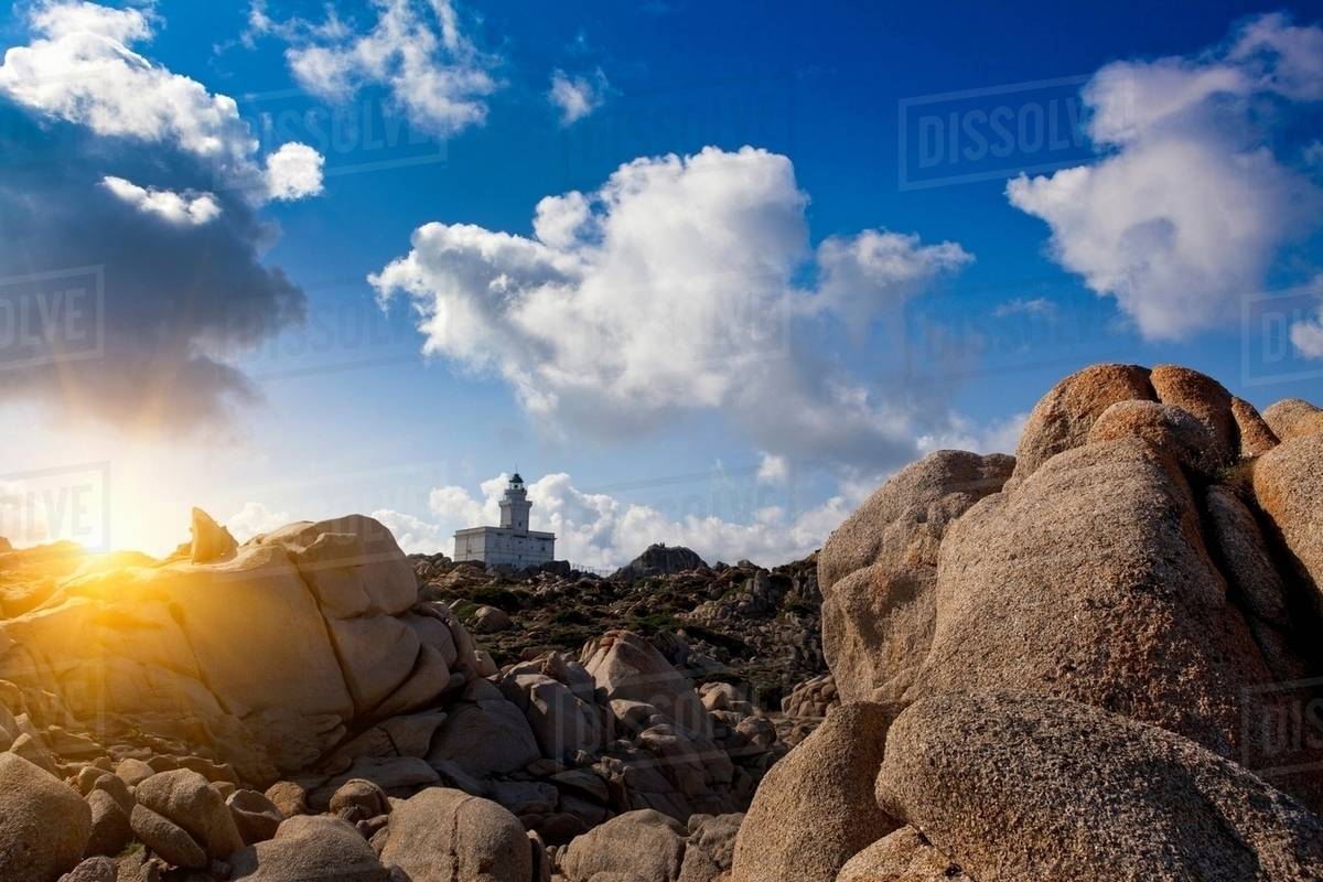 Lighthouse on rocky coastline - Stock Photo - Dissolve