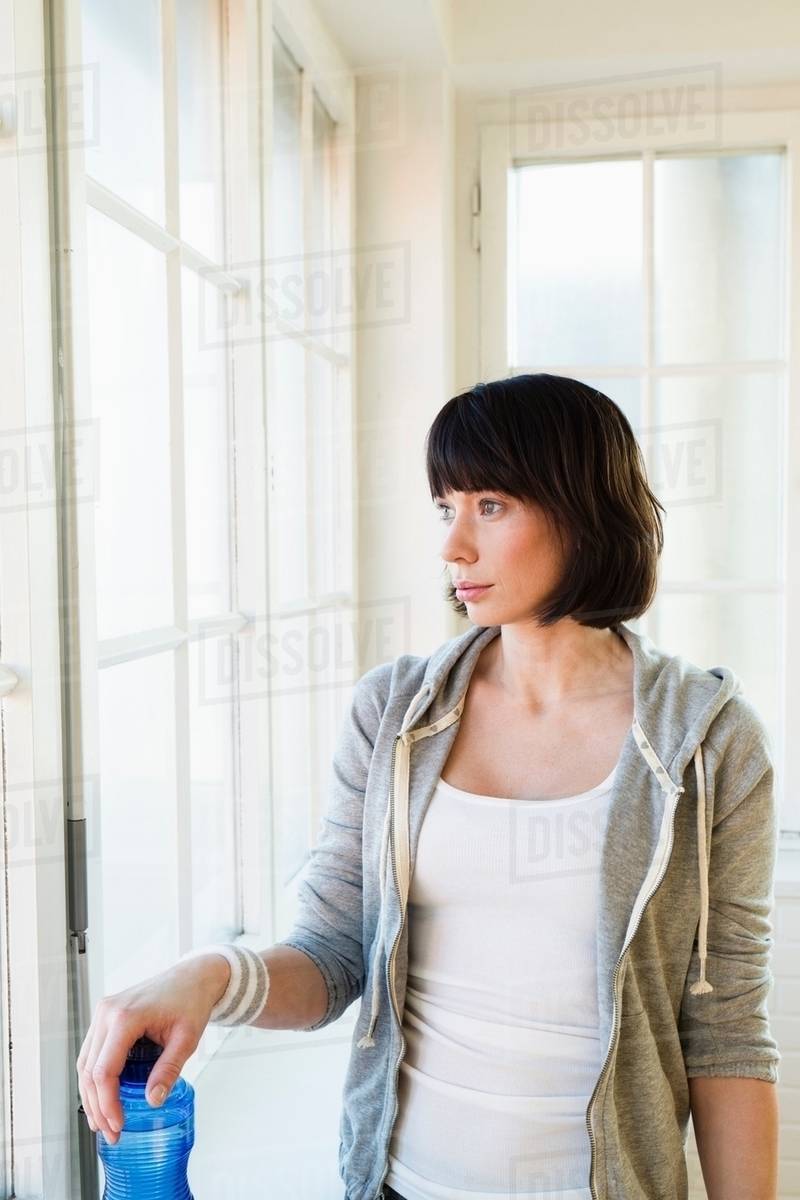 Woman standing at window - Stock Photo - Dissolve