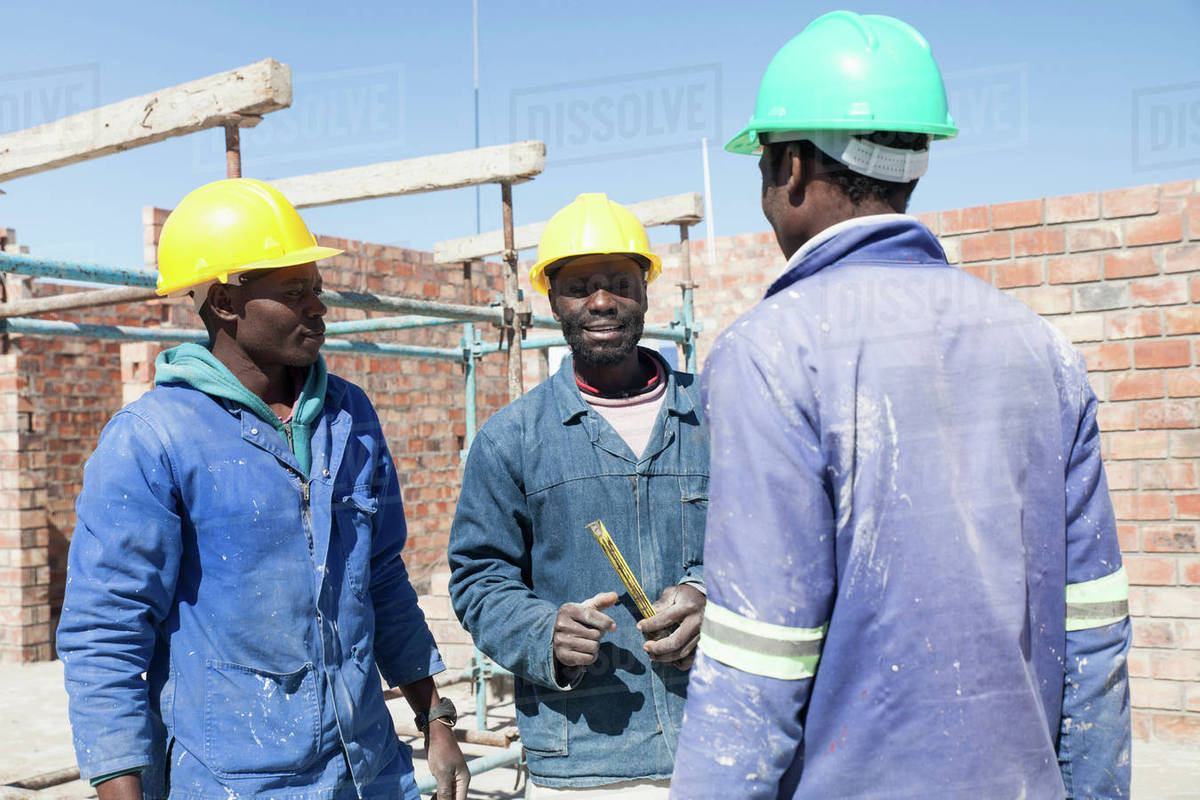 Builders talking on construction site - Royalty-free Stock Photo | Dissolve