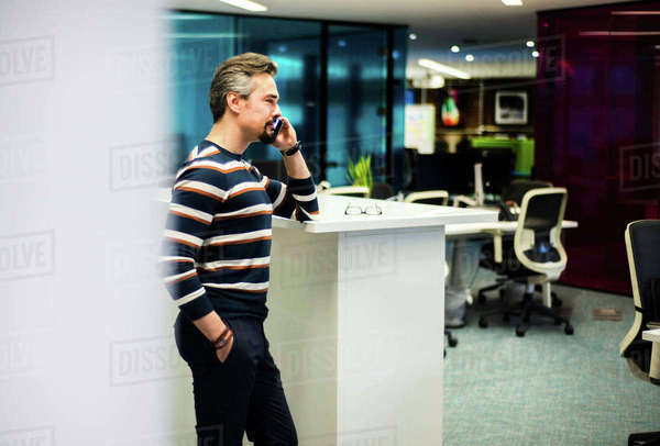 Businessman working late in office making smartphone call - Royalty ...