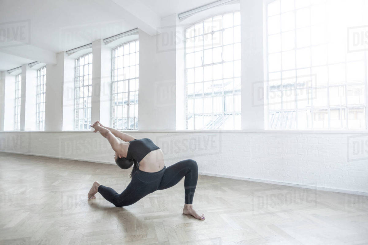 Woman in dance studio bending backwards stretching - Royalty-free Stock ...