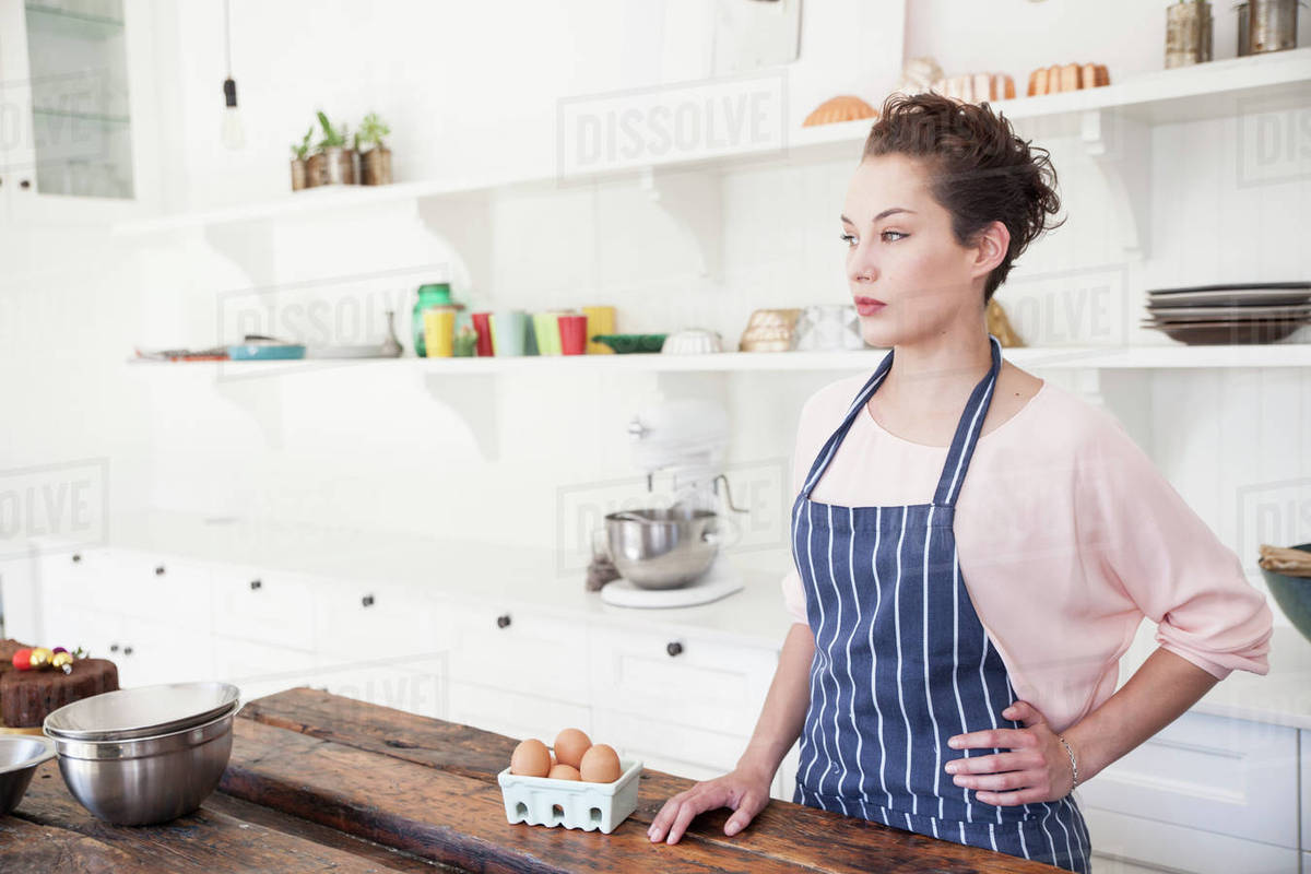 Young woman standing at kitchen counter with carton of eggs - Royalty ...