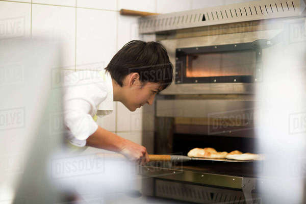 Young woman cooking food in fast food shop - Stock Photo - Dissolve