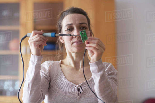 Woman using soldering iron - Royalty-free Stock Photo | Dissolve