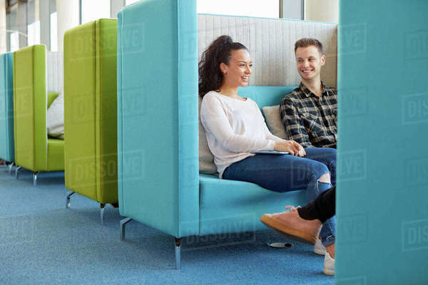 University students relaxing in modern cubicle seating area - Stock ...