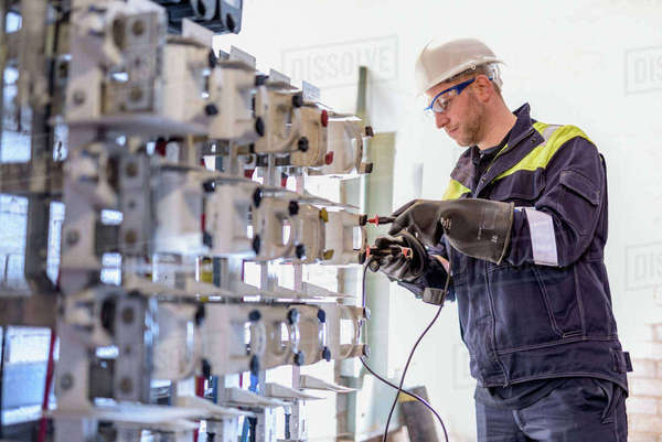 Worker testing circuit breakers in electricity substation - Stock Photo ...