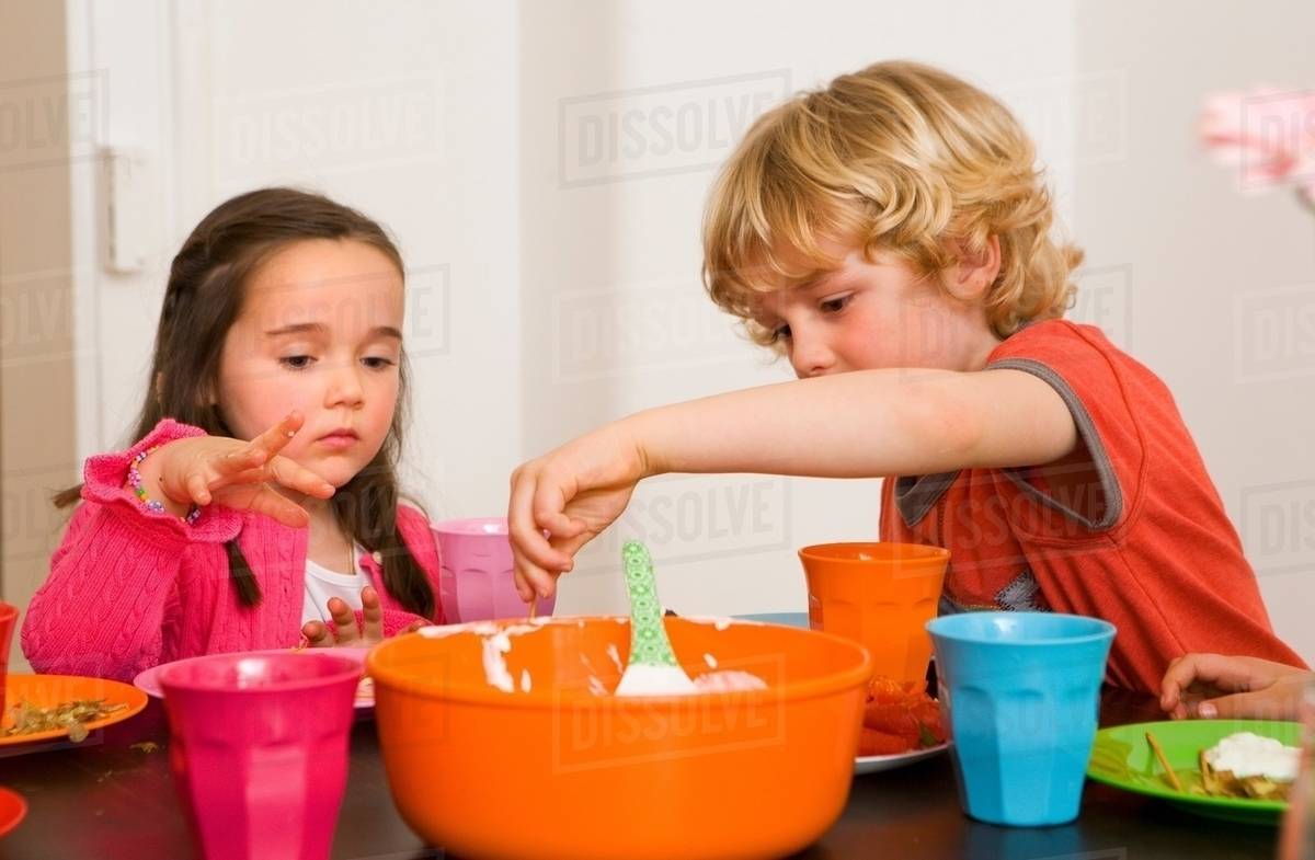Children dipping vegetables in sauce - Royalty-free Stock Photo | Dissolve