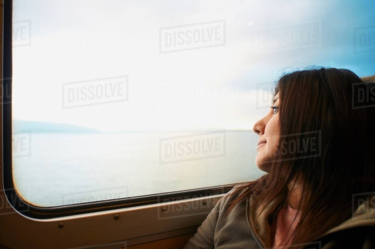 Woman looking out train window - Stock Photo - Dissolve