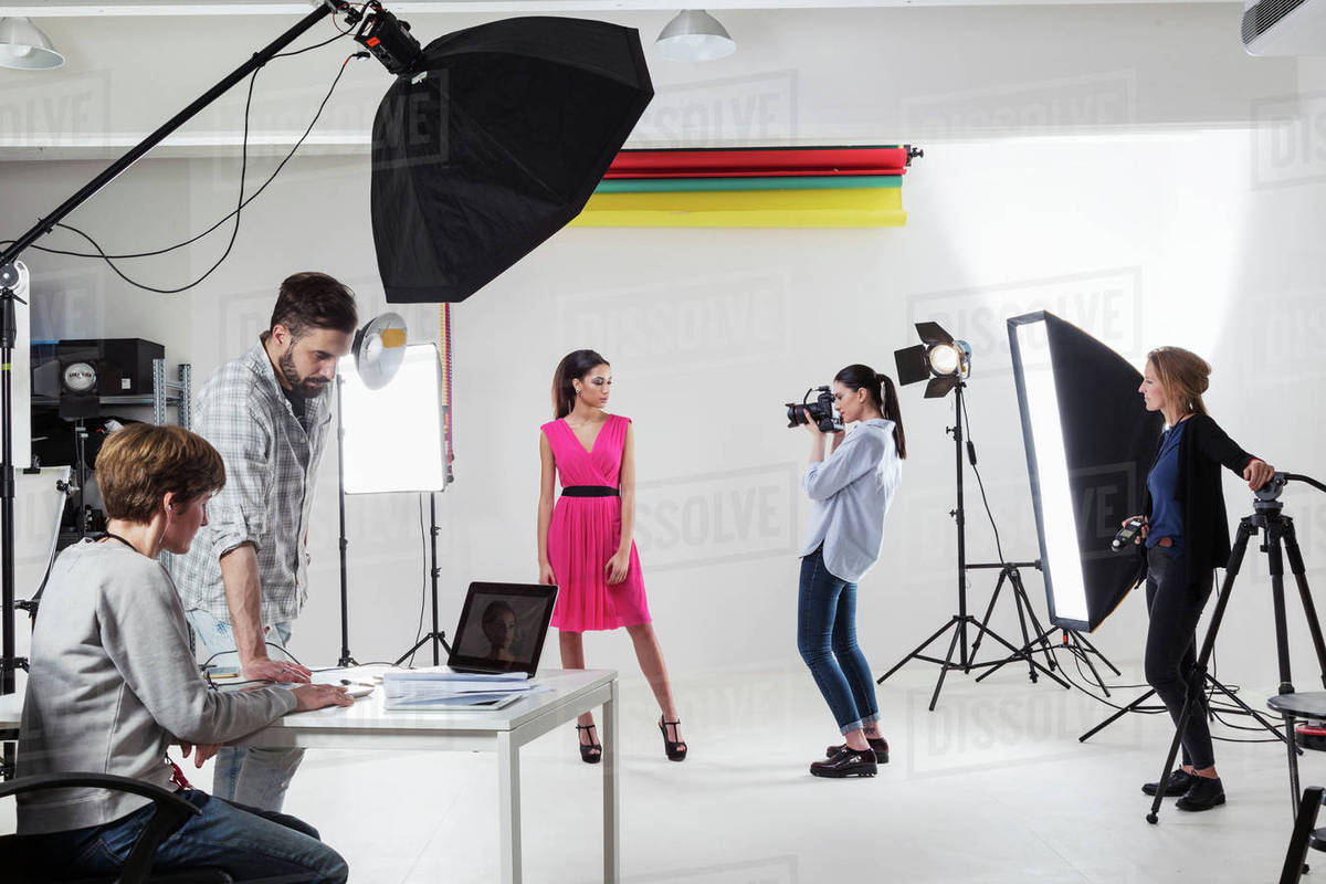 Photographer photographing fashion model in white backdrop photography ...