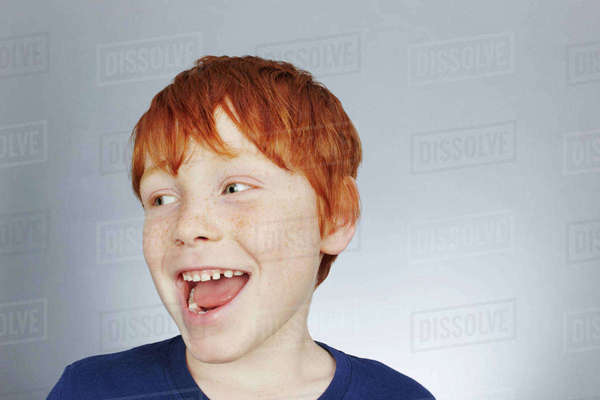 Studio portrait of smiling red haired boy looking sideways - Stock ...