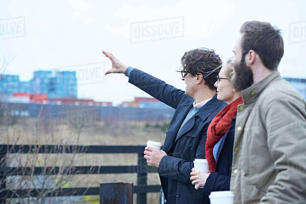 Rear view of design team pointing outside design studio - Royalty-free ...