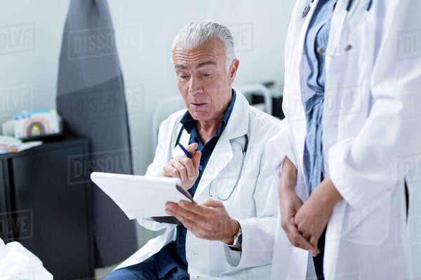 Doctor looking at medical chart - Royalty-free Stock Photo | Dissolve