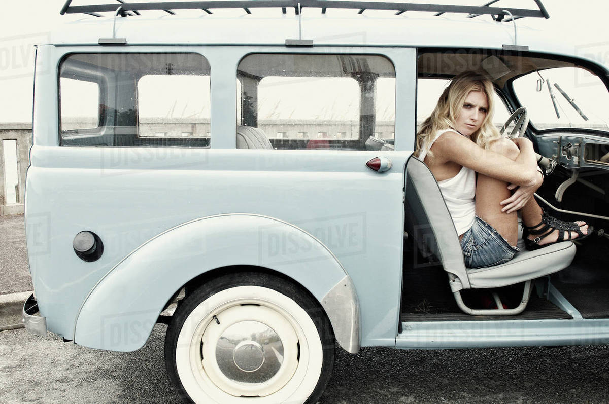 Woman hugging her knees in car - Royalty-free Stock Photo | Dissolve