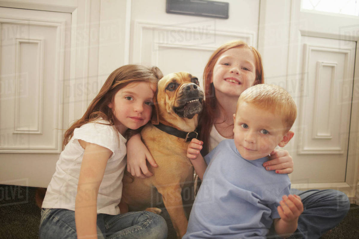 Children hugging dog on floor - Royalty-free Stock Photo | Dissolve