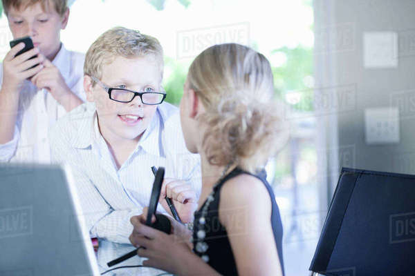 Children playing business people at desk - Stock Photo - Dissolve