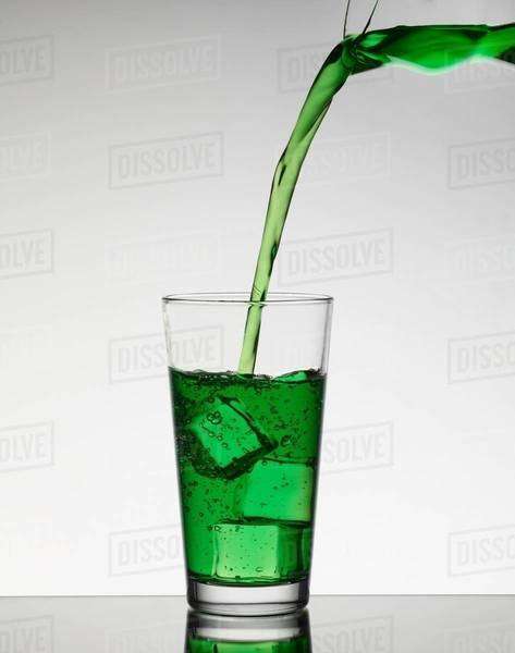 Juice pouring over ice in glass - Stock Photo - Dissolve