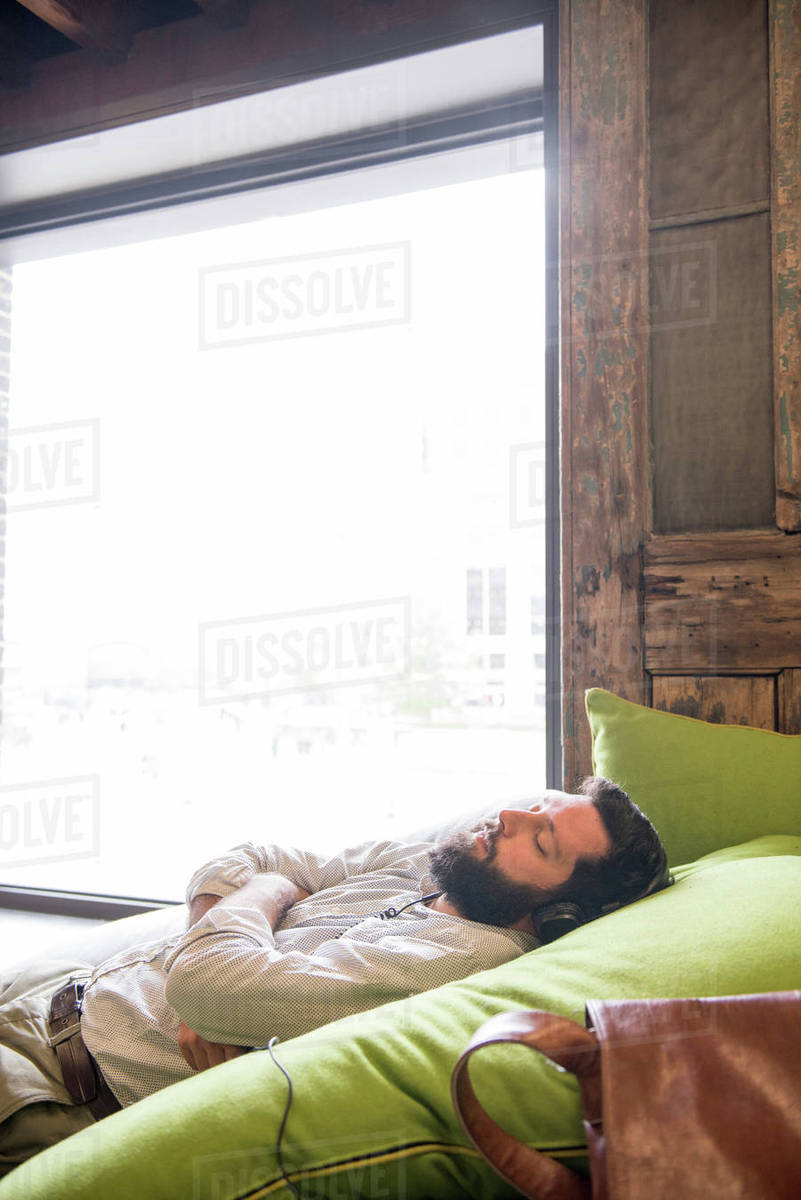 Man reclining on sofa napping - Royalty-free Stock Photo | Dissolve