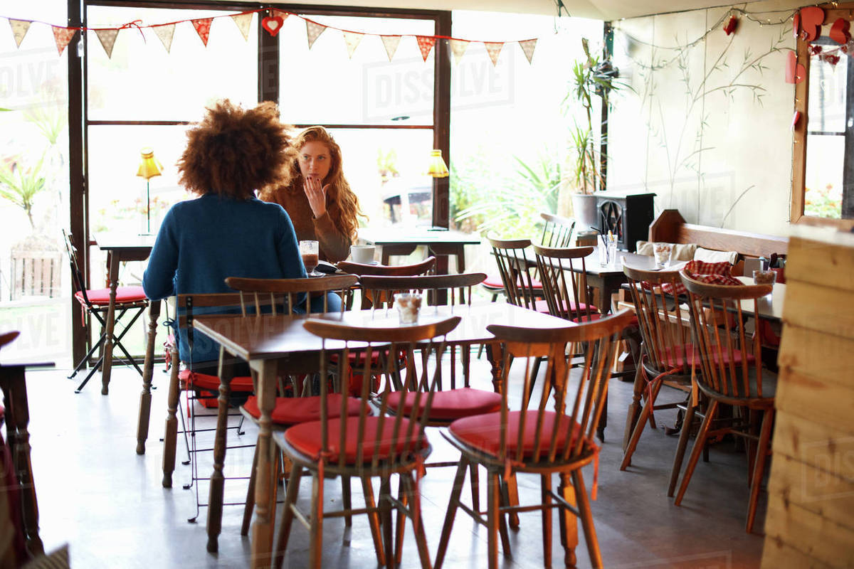 Friends relaxing in cafe, chatting - Royalty-free Stock Photo | Dissolve