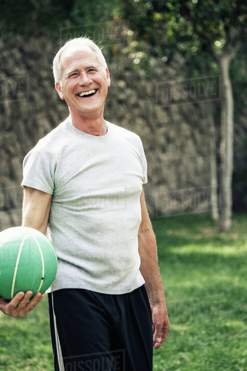 Portrait of man holding basketball looking at camera smiling - Royalty ...