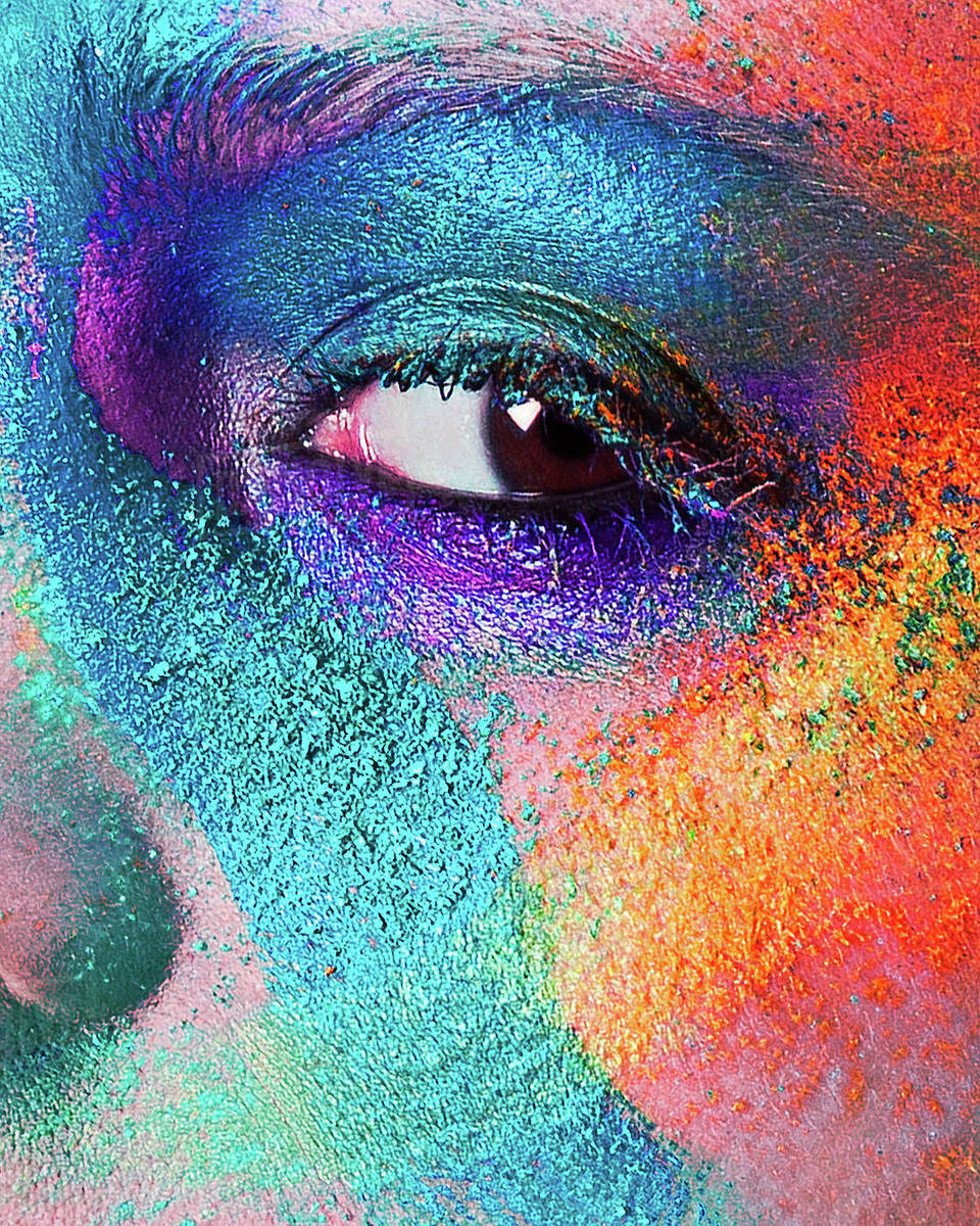 Studio portrait of young woman's face with multi coloured powder eye ...