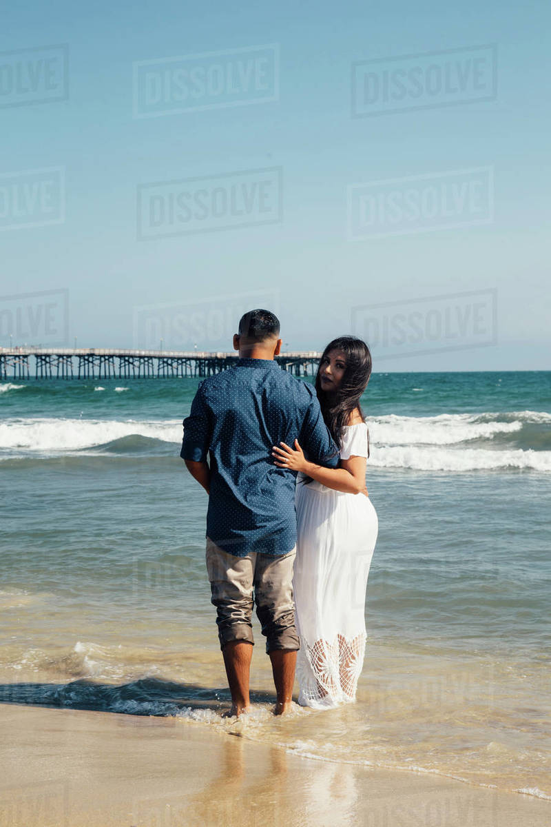 Couple standing on beach, rear view, Seal Beach, California, USA ...