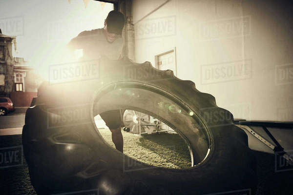 Man lifting large tire - Royalty-free Stock Photo | Dissolve