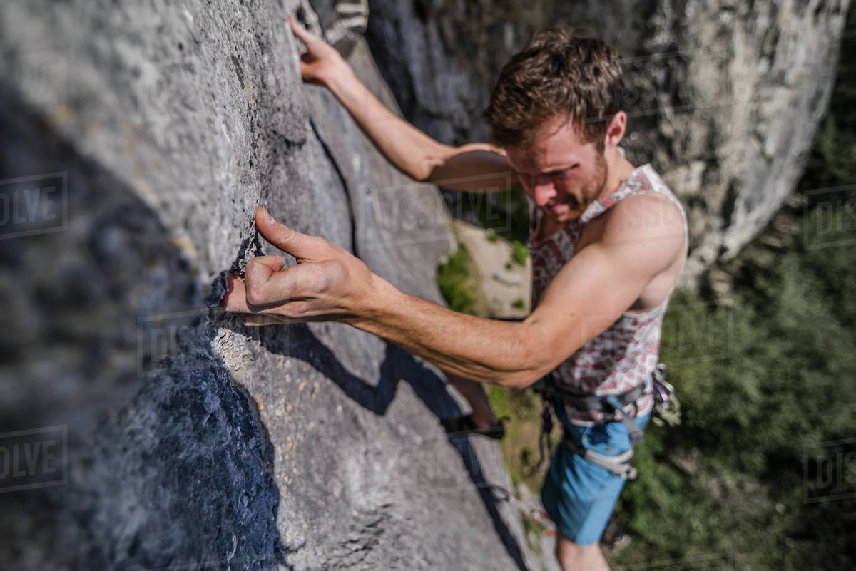 Young male rock climber climbing limestone rock face, Freyr, Belgium ...