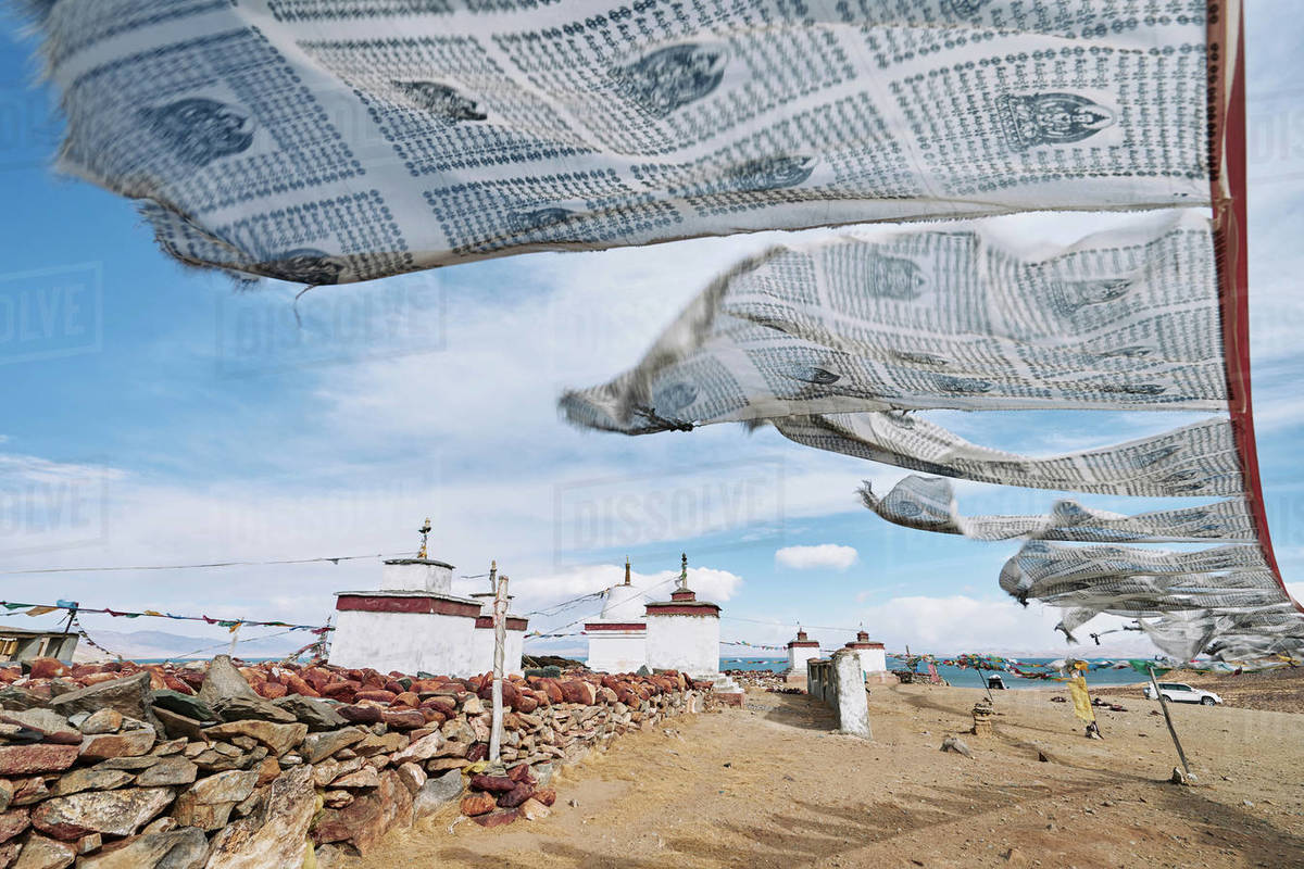 Mantra flags on beach, Burang, Xizang, China - Stock Photo - Dissolve