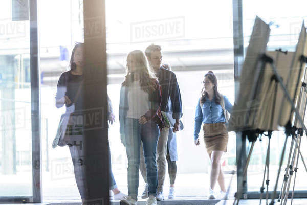 Students entering college building by glass doors - Stock Photo - Dissolve