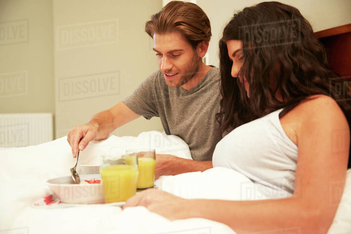 Couple sharing fruit and orange juice breakfast in bed - Royalty-free ...