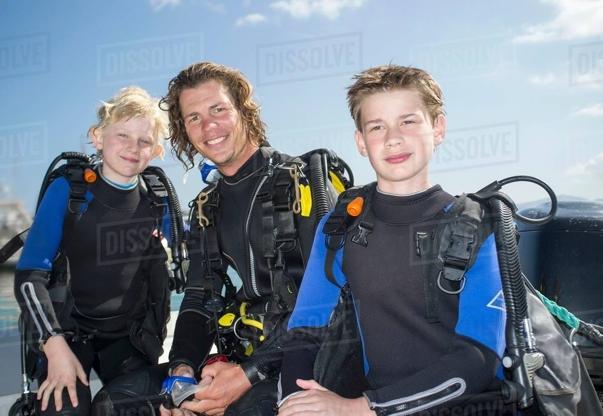Portrait of two boys with mid adult male scuba diving teacher - Stock ...