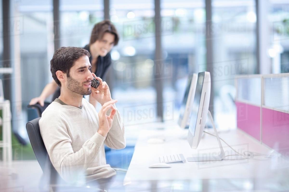 Male office worker on landline phone - Stock Photo - Dissolve