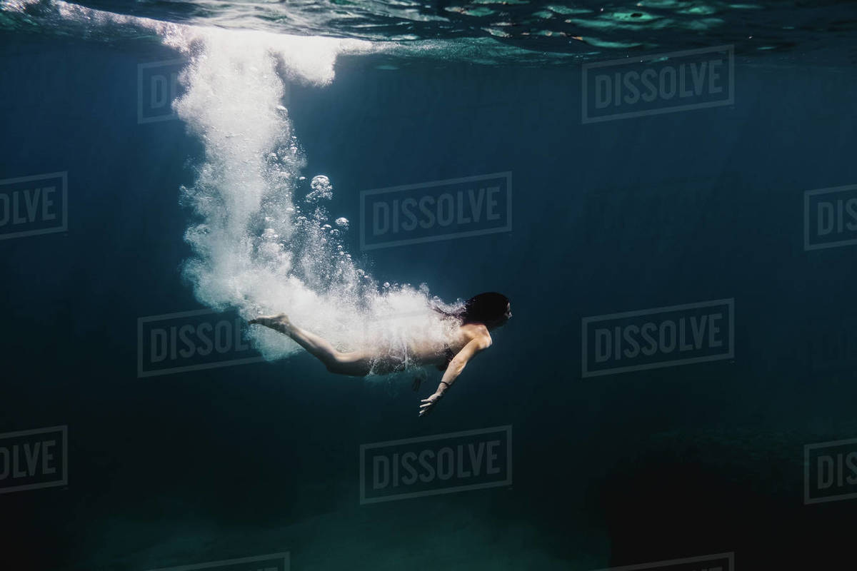 Woman diving underwater, underwater view, Stintino, Sardinia, Italy ...