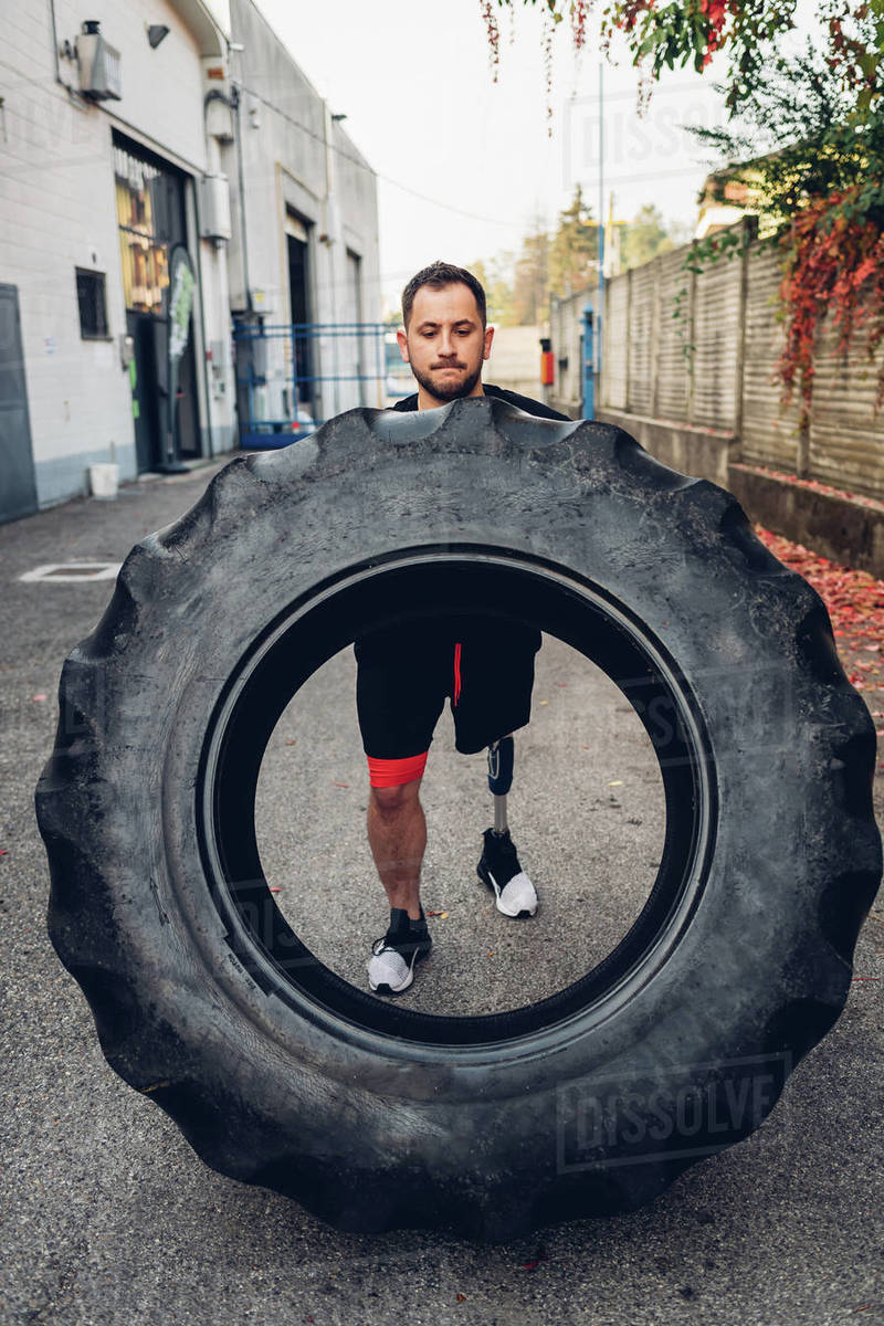 Man with prosthetic leg weight training with giant tyre - Royalty-free ...