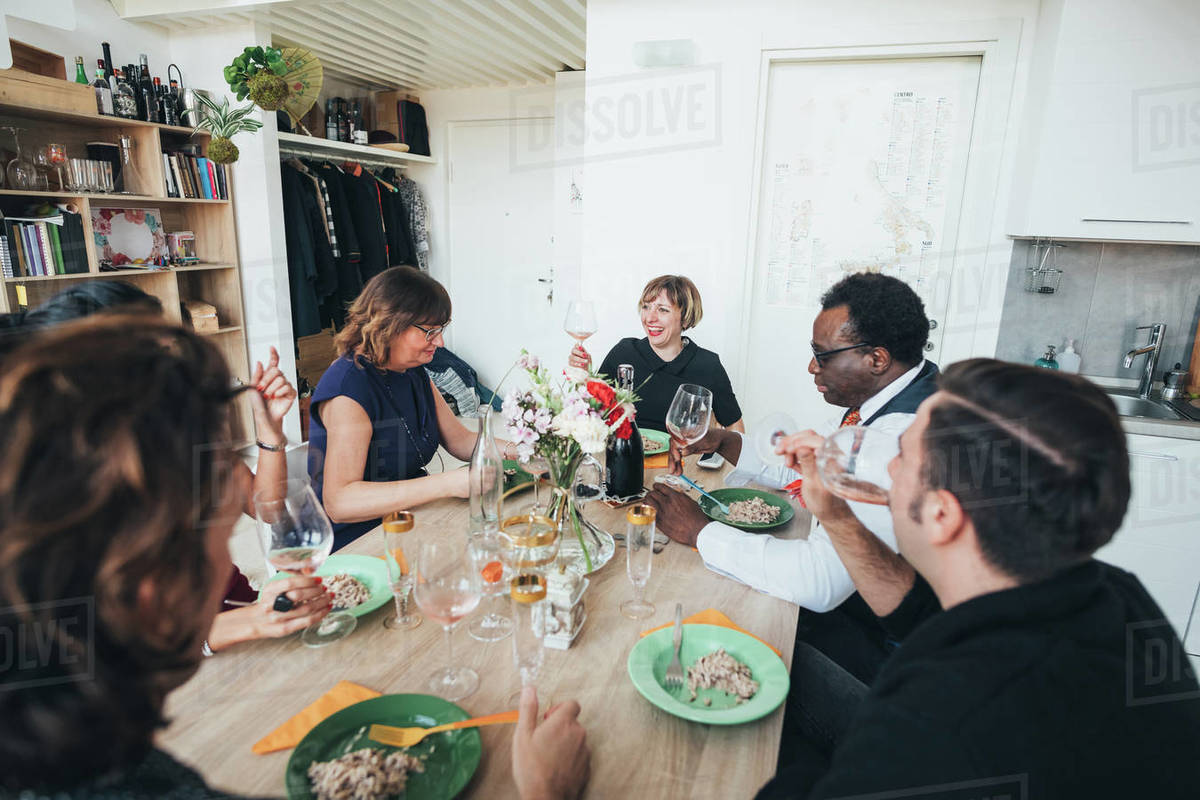 Businessmen and businesswomen celebrating at lunch party in loft office ...