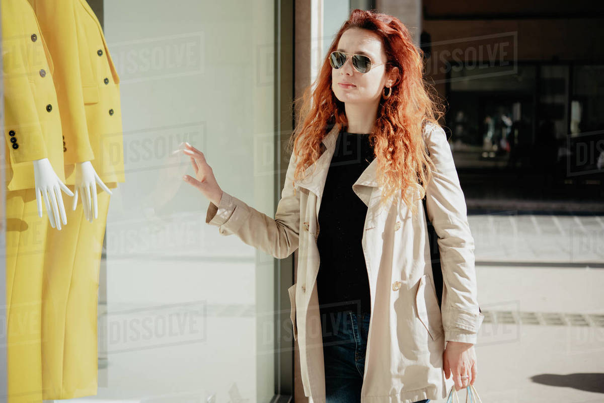 Woman looking into window of fashion boutique - Royalty-free Stock ...